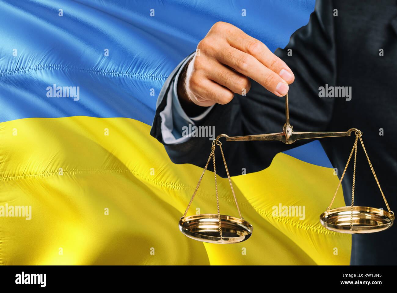 Ukrainian Judge is holding golden scales of justice with Ukraine waving ...
