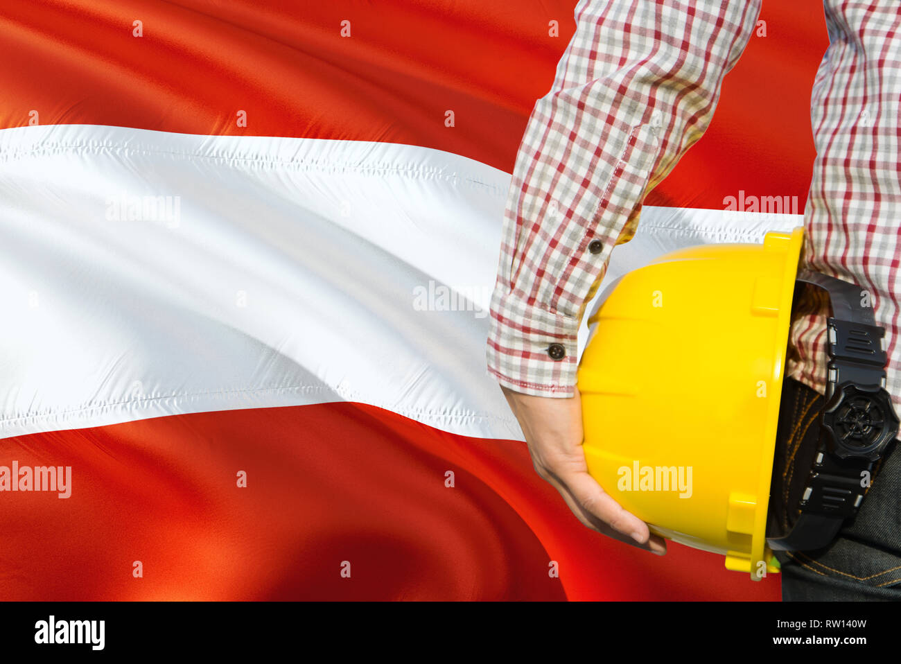 Austrian Engineer is holding yellow safety helmet with waving Austria ...