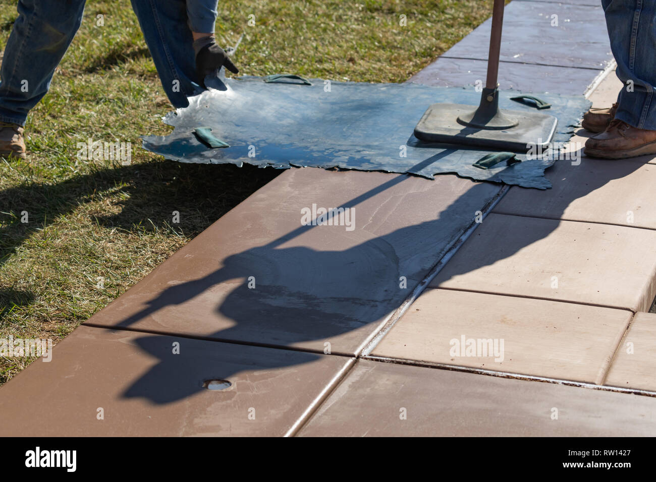 Construction Worker Applying Pressure to Texture Template On Wet Cement ...