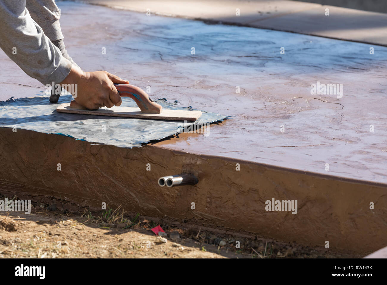 Construction Worker Applying Pressure to Texture Template On Wet Cement ...