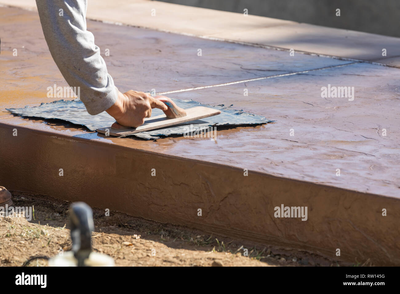 Construction Worker Applying Pressure to Texture Template On Wet Cement ...