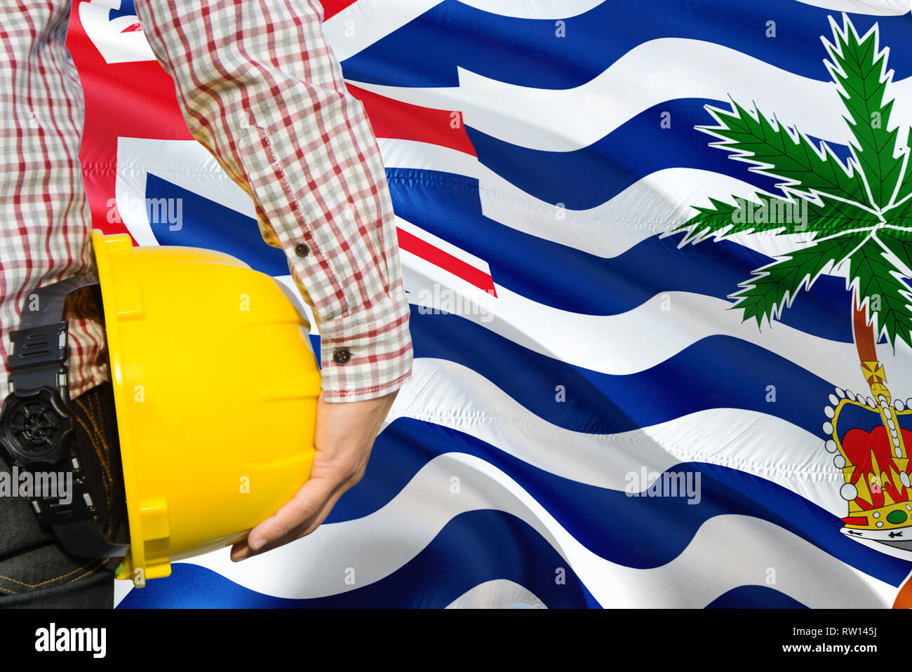 Engineer is holding yellow safety helmet with waving British Indian ...