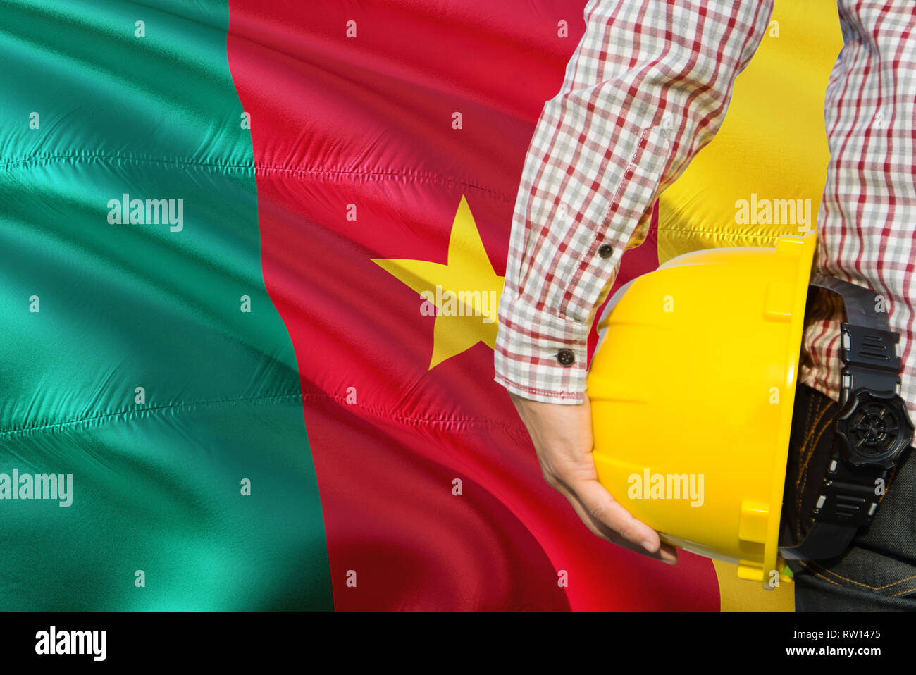 Cameroonian Engineer is holding yellow safety helmet with waving ...