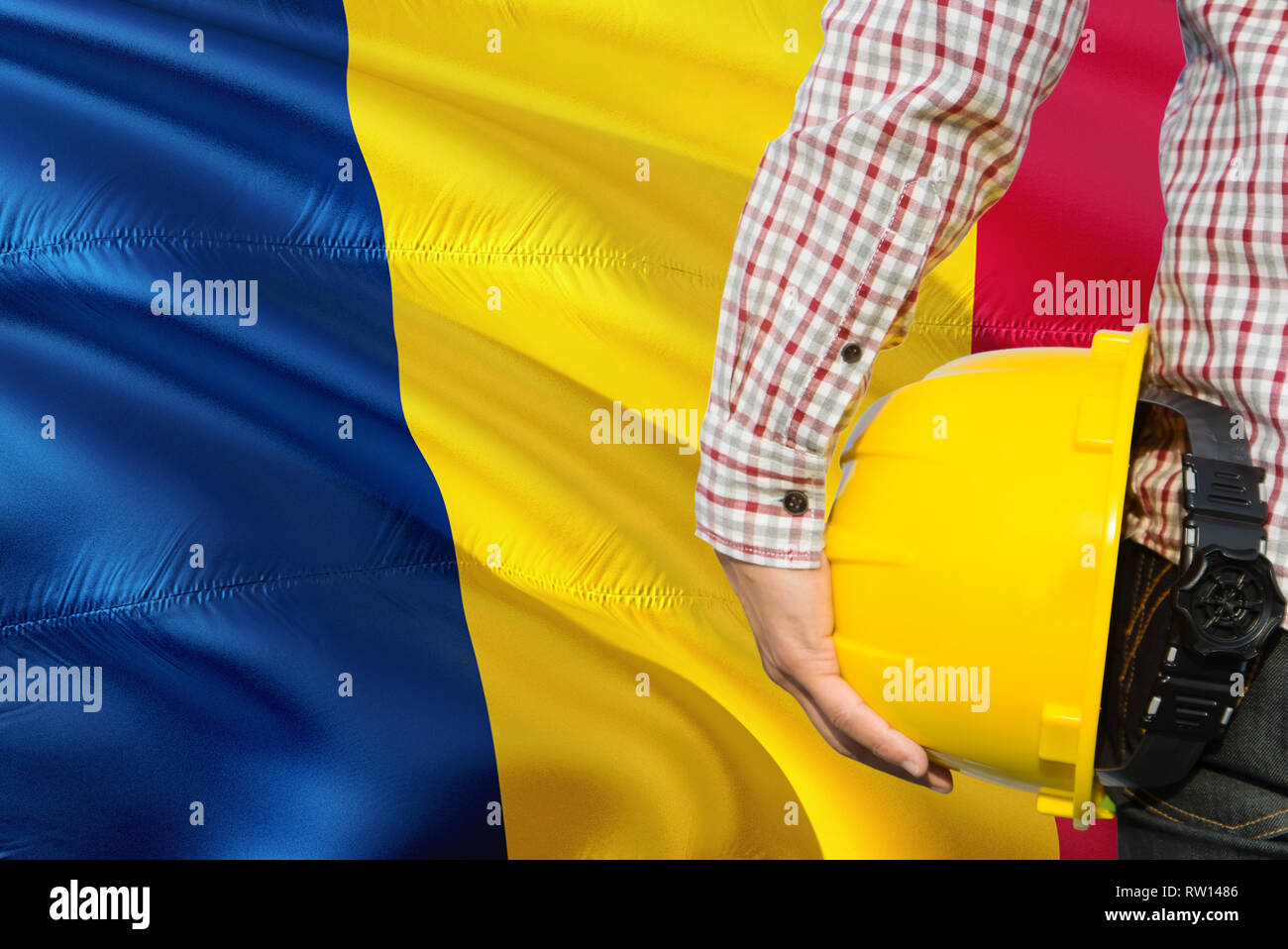 Chadian Engineer is holding yellow safety helmet with waving Chad flag ...