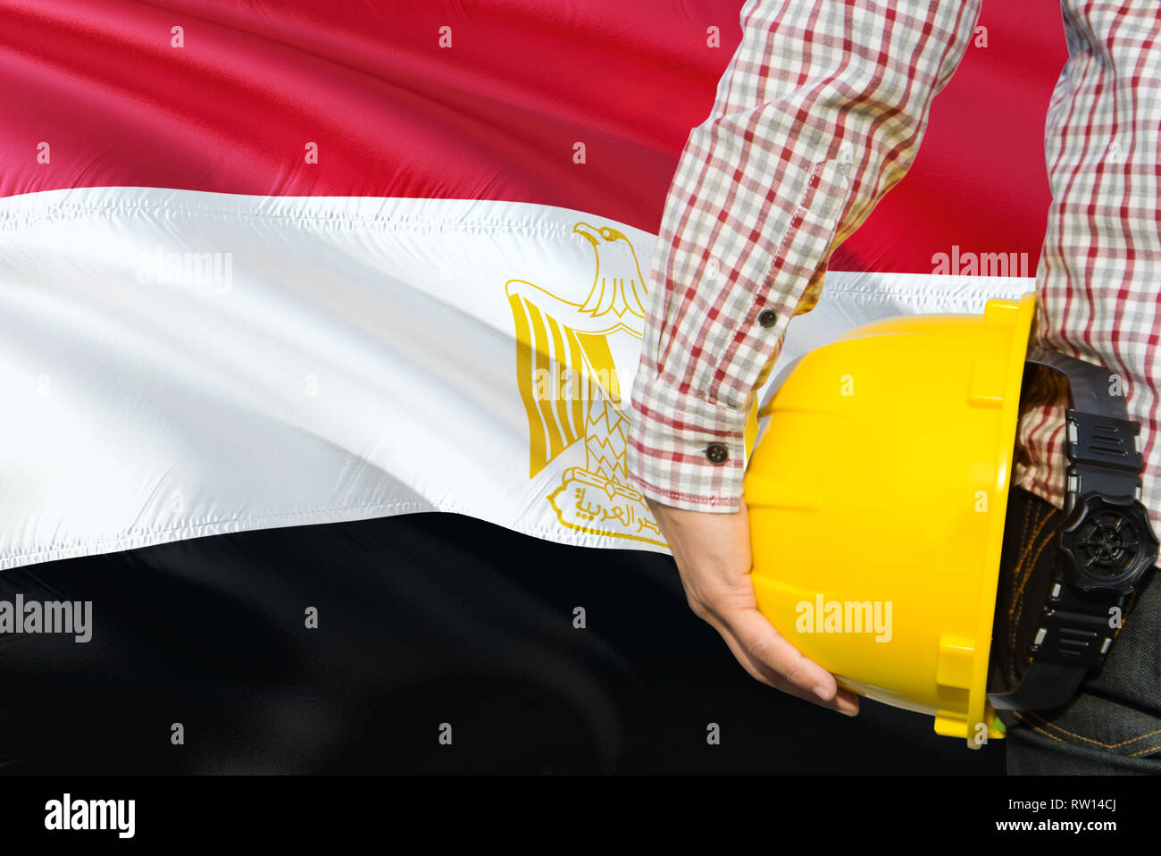 Egyptian Engineer is holding yellow safety helmet with waving Egypt ...