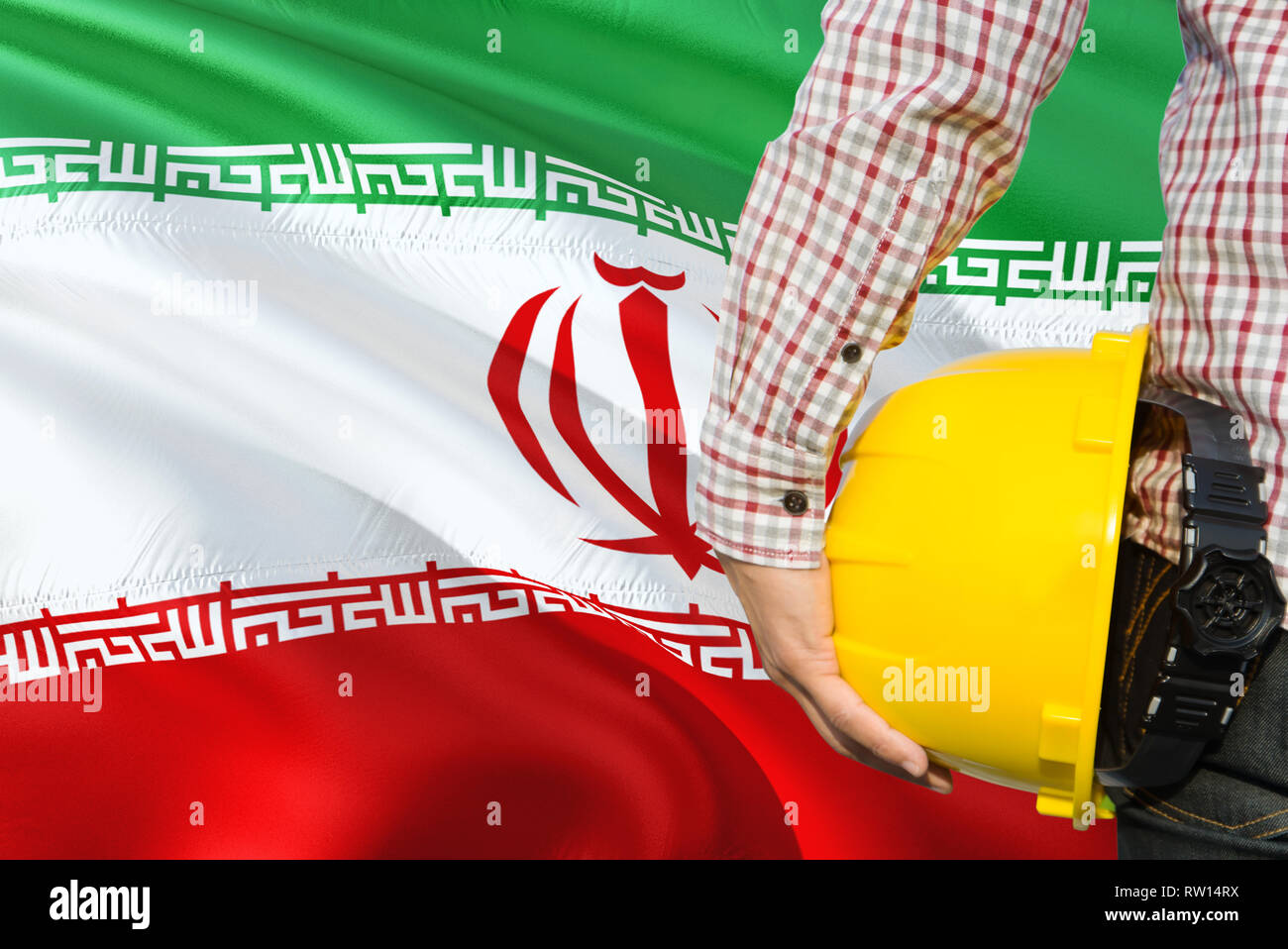 Iranian Engineer is holding yellow safety helmet with waving Iran flag ...