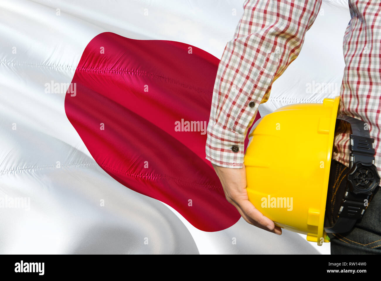 Japanese Engineer is holding yellow safety helmet with waving Japan ...