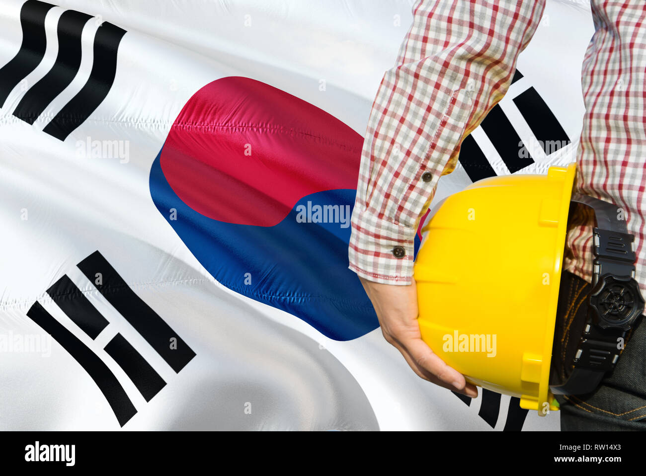 South Korean Engineer is holding yellow safety helmet with waving South ...