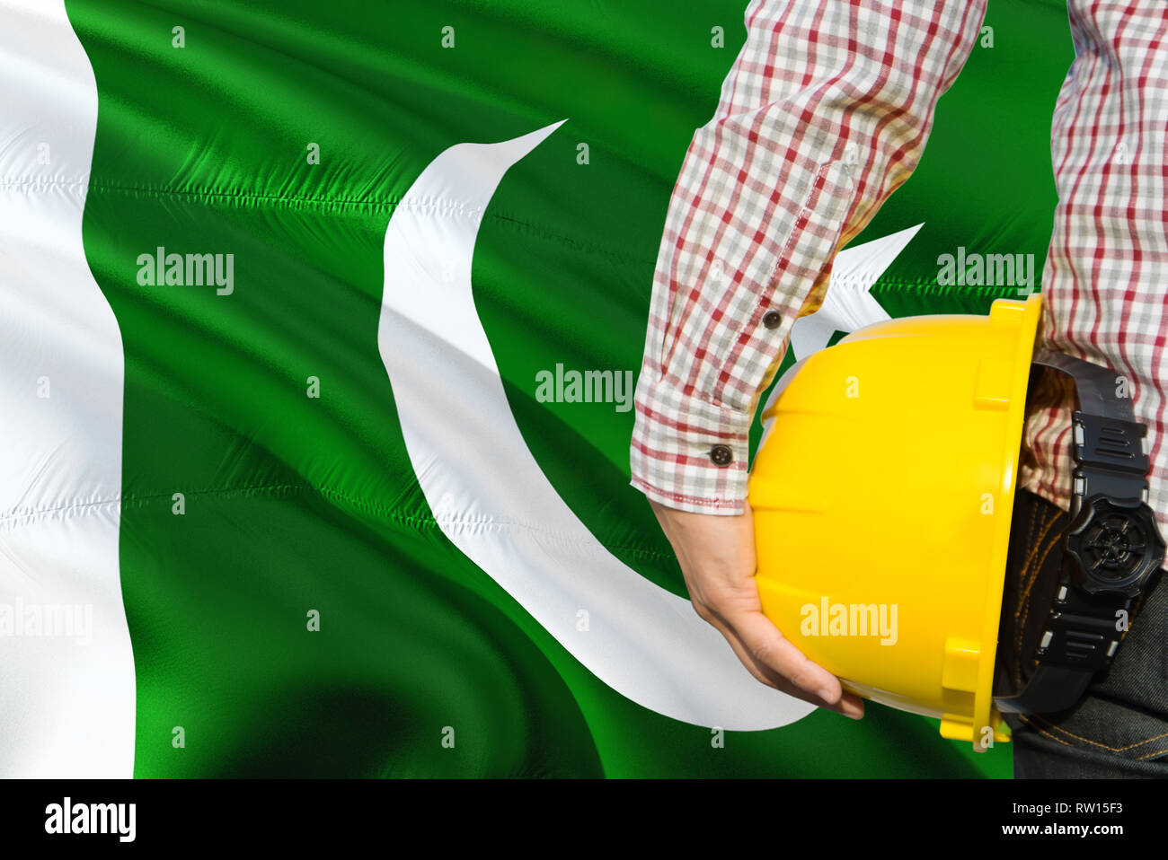 Pakistani Engineer is holding yellow safety helmet with waving Pakistan ...