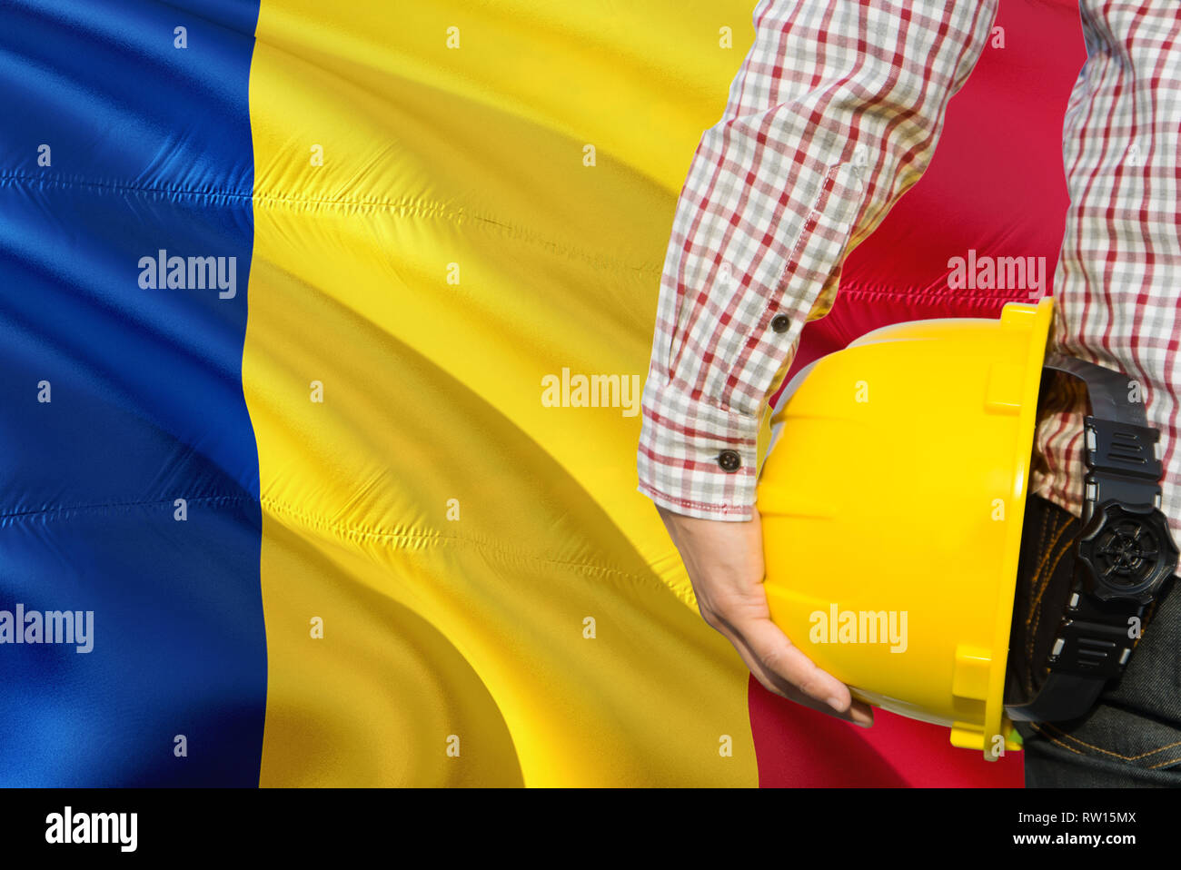 Romanian Engineer is holding yellow safety helmet with waving Romania ...