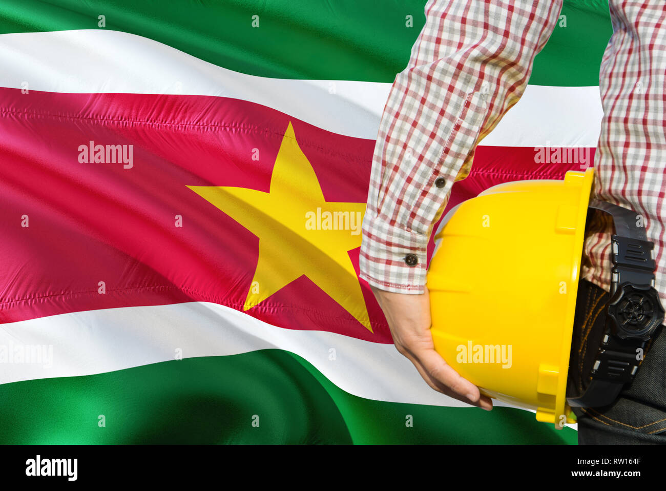 Surinamese Engineer is holding yellow safety helmet with waving ...