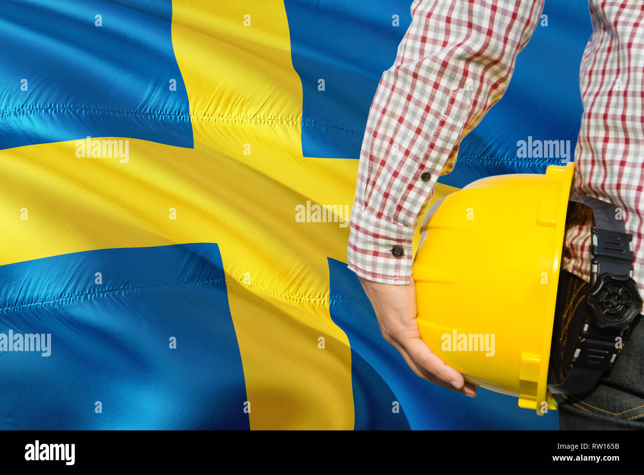 Swedish Engineer is holding yellow safety helmet with waving Sweden ...