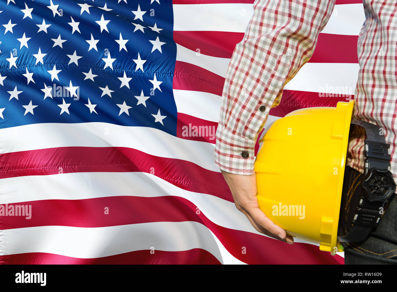 American Engineer is holding yellow safety helmet with waving United ...