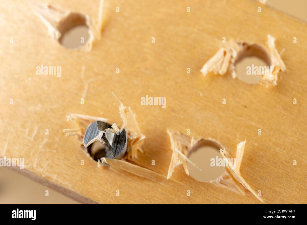 Drilling a hole in wood. Wood drill and plywood in a carpentry workshop ...