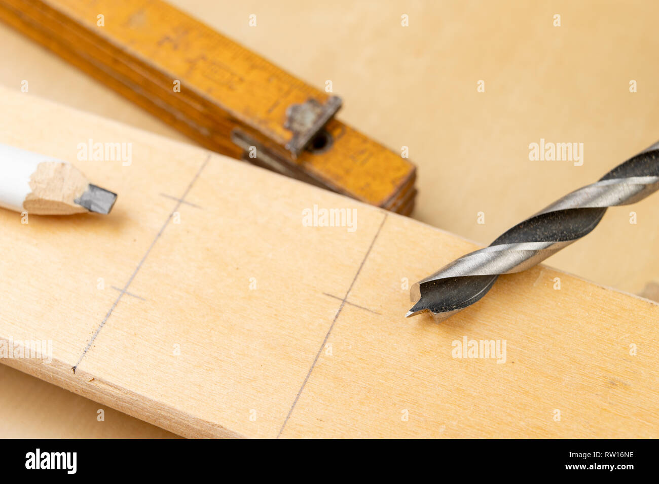 Drilling a hole in wood. Wood drill and plywood in a carpentry workshop ...