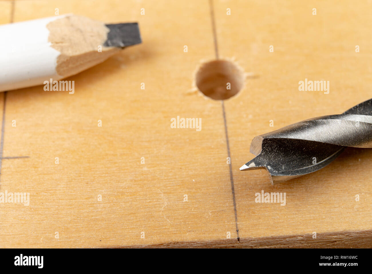 Drilling a hole in wood. Wood drill and plywood in a carpentry workshop ...