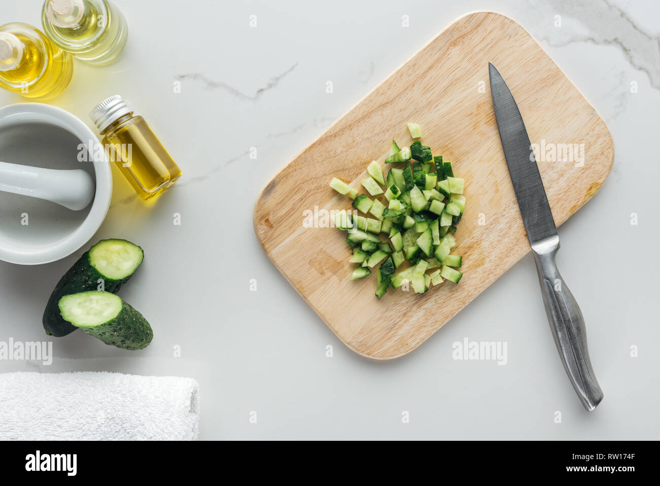 top with of wooden cutting desk with cut cucumber cubes, and various ...