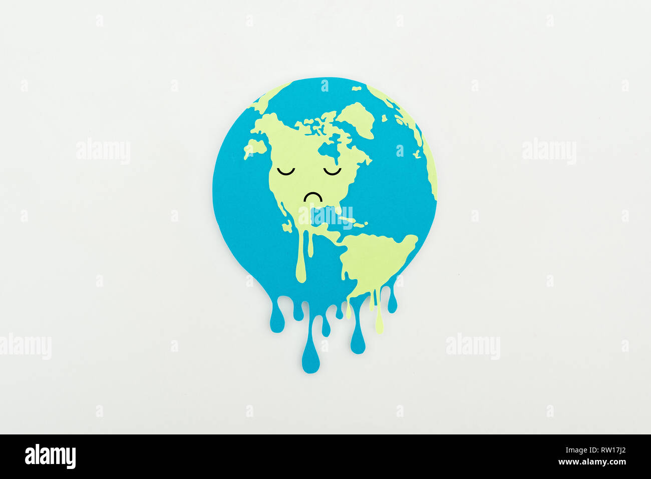 melting paper cut globe with sad face expression on grey background ...