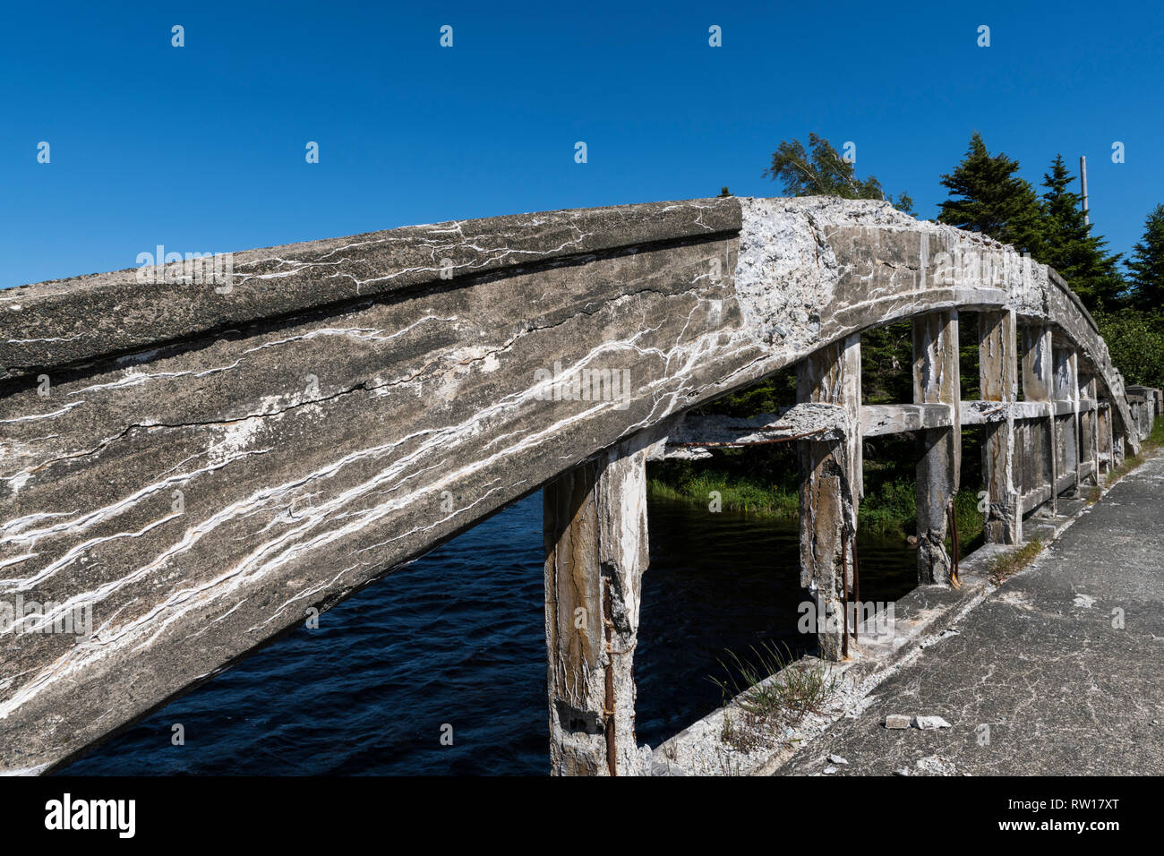 Built in 1929, decaying old bridge showing rusting rebar, crosses over ...
