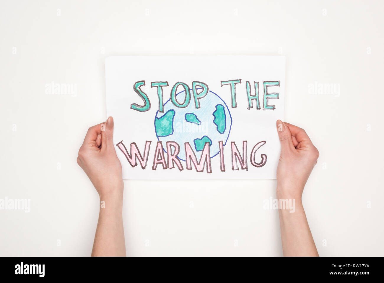 partial view of woman holding card with melting globe sign and "stop ...