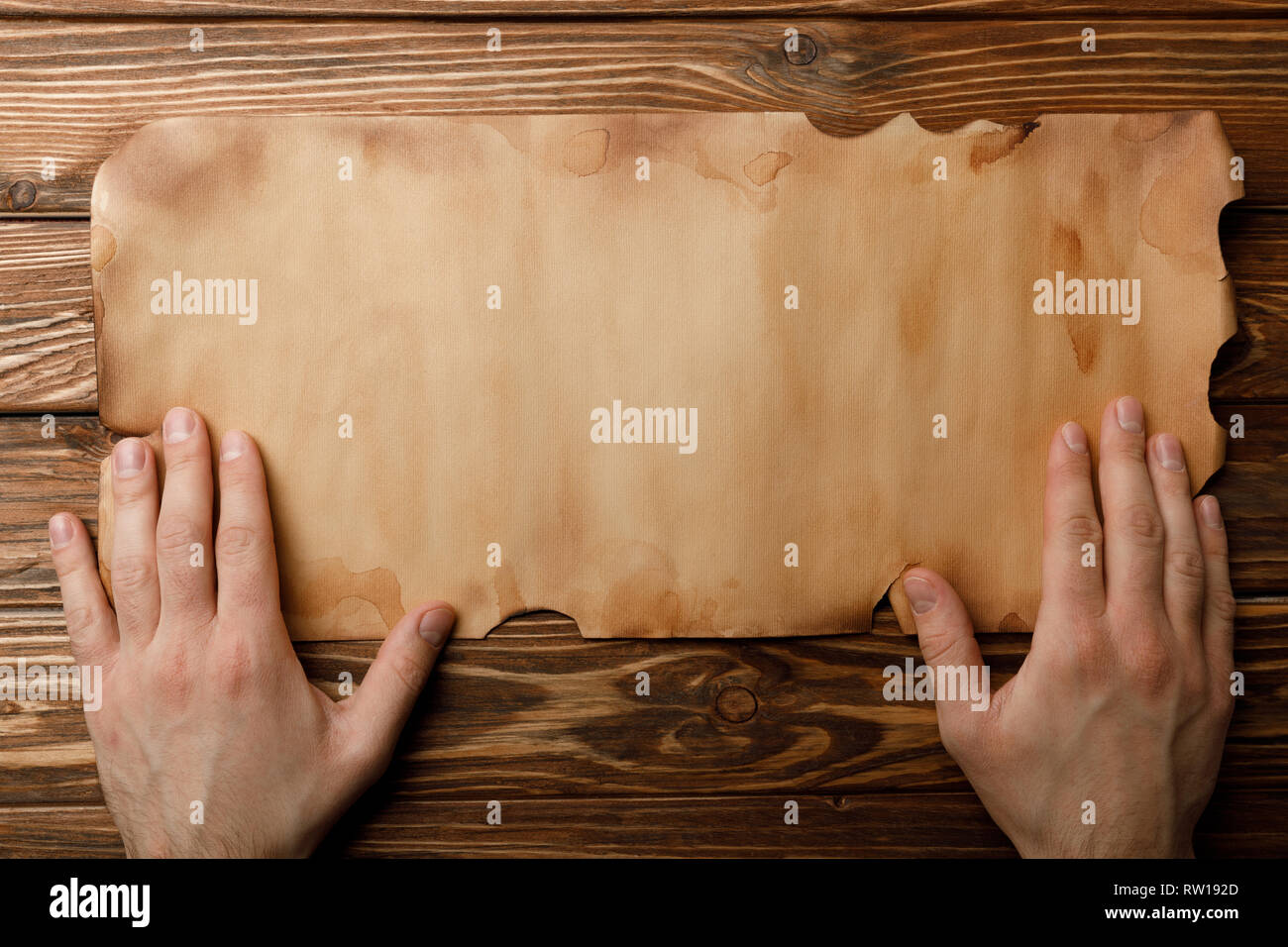top view of man holding hands near aged parchment sheet Stock Photo - Alamy