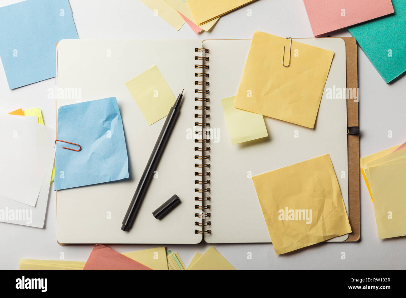 top view of opened notebook with sticky notes with paper clips and ...