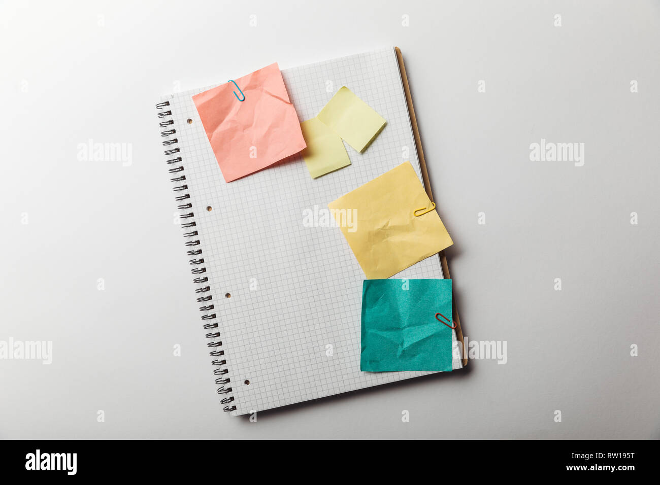 top view of notebook with blank squared page near crumpled sticky notes ...