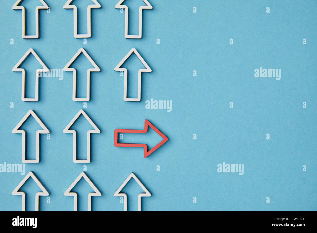 top view of horizontal red arrow among white vertical pointers on blue ...