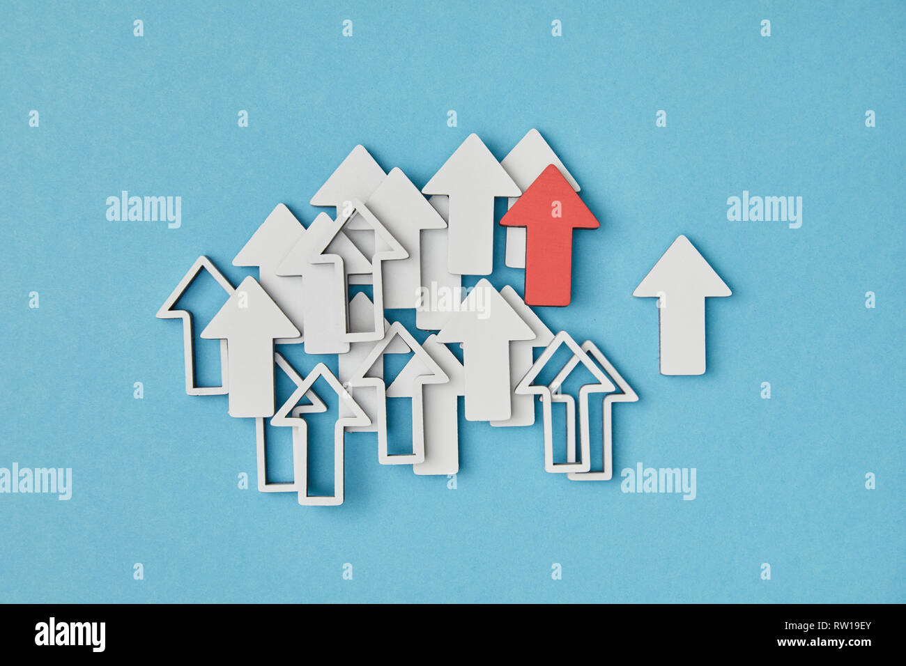 top view of red vertical pointer with white arrows on blue background ...