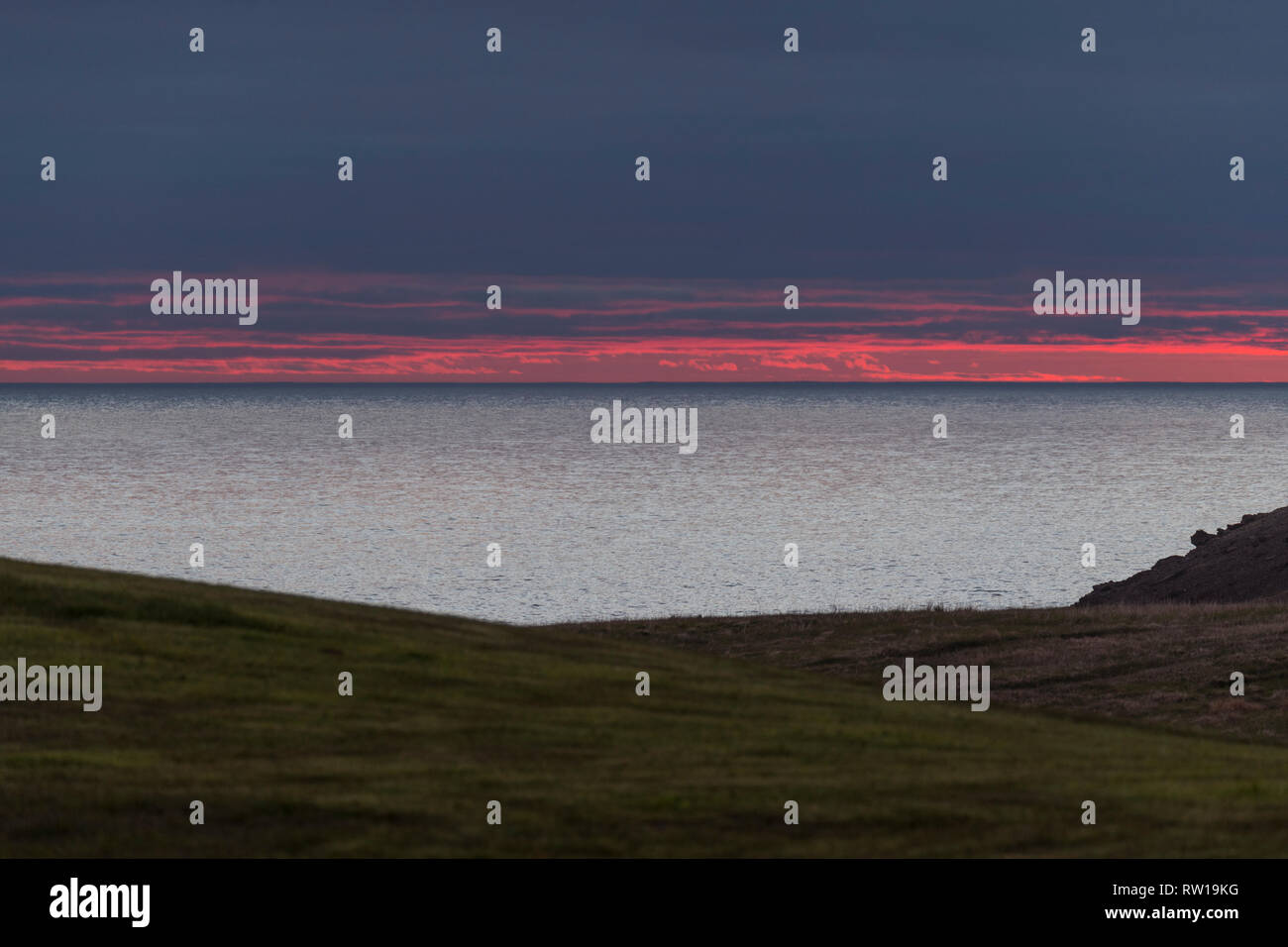 Sunset on the ocean in St. Bride's, Newfoundland, Canada, red sky and a ...