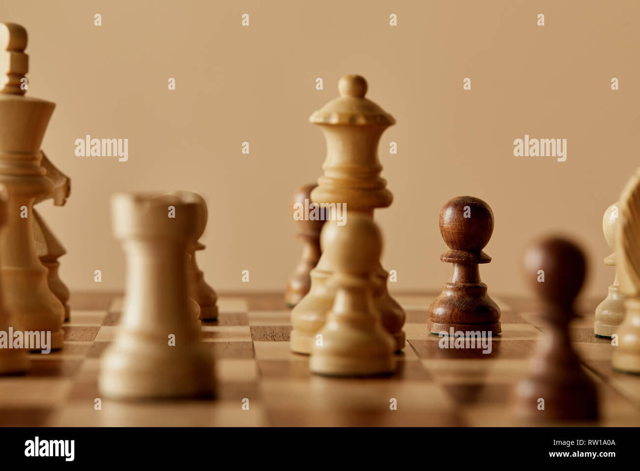 selective focus of chess pieces on chess board and beige background ...