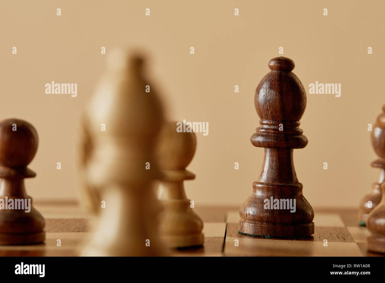 selective focus of brown chess piece on chess board and beige ...