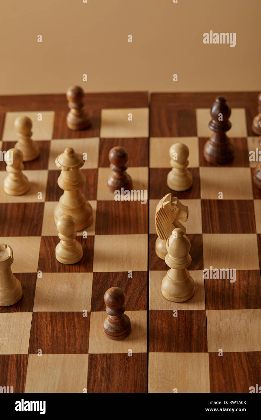 chess pieces on wooden chess board and beige background Stock Photo - Alamy