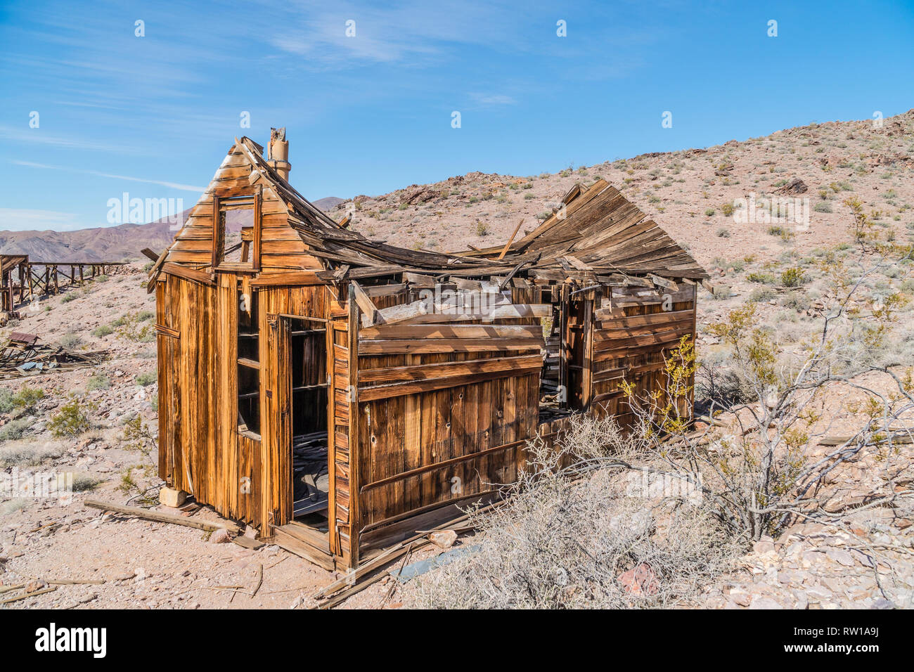 A wooden house with a collapsed swayback roof at the Inyo Mine ruins in ...