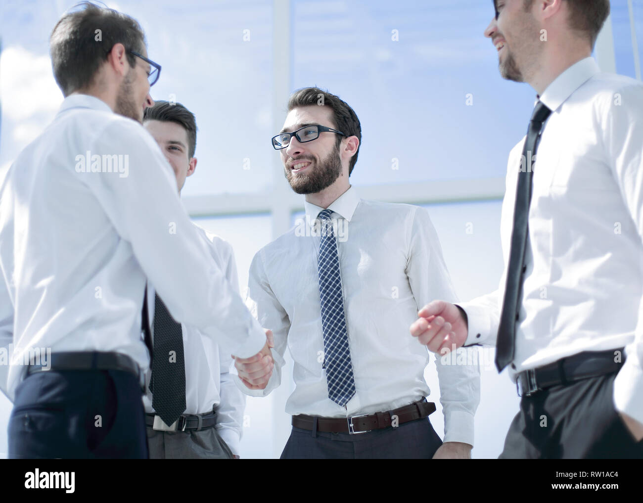 business people shaking hands while standing in the office Stock Photo ...