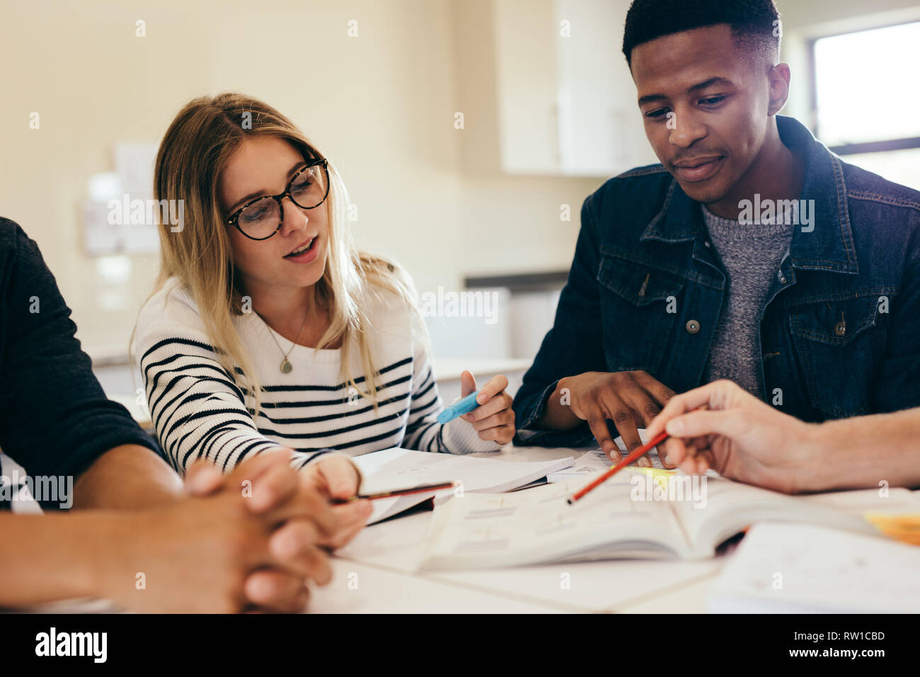 Group of multi-ethnic college students studying together in a library ...