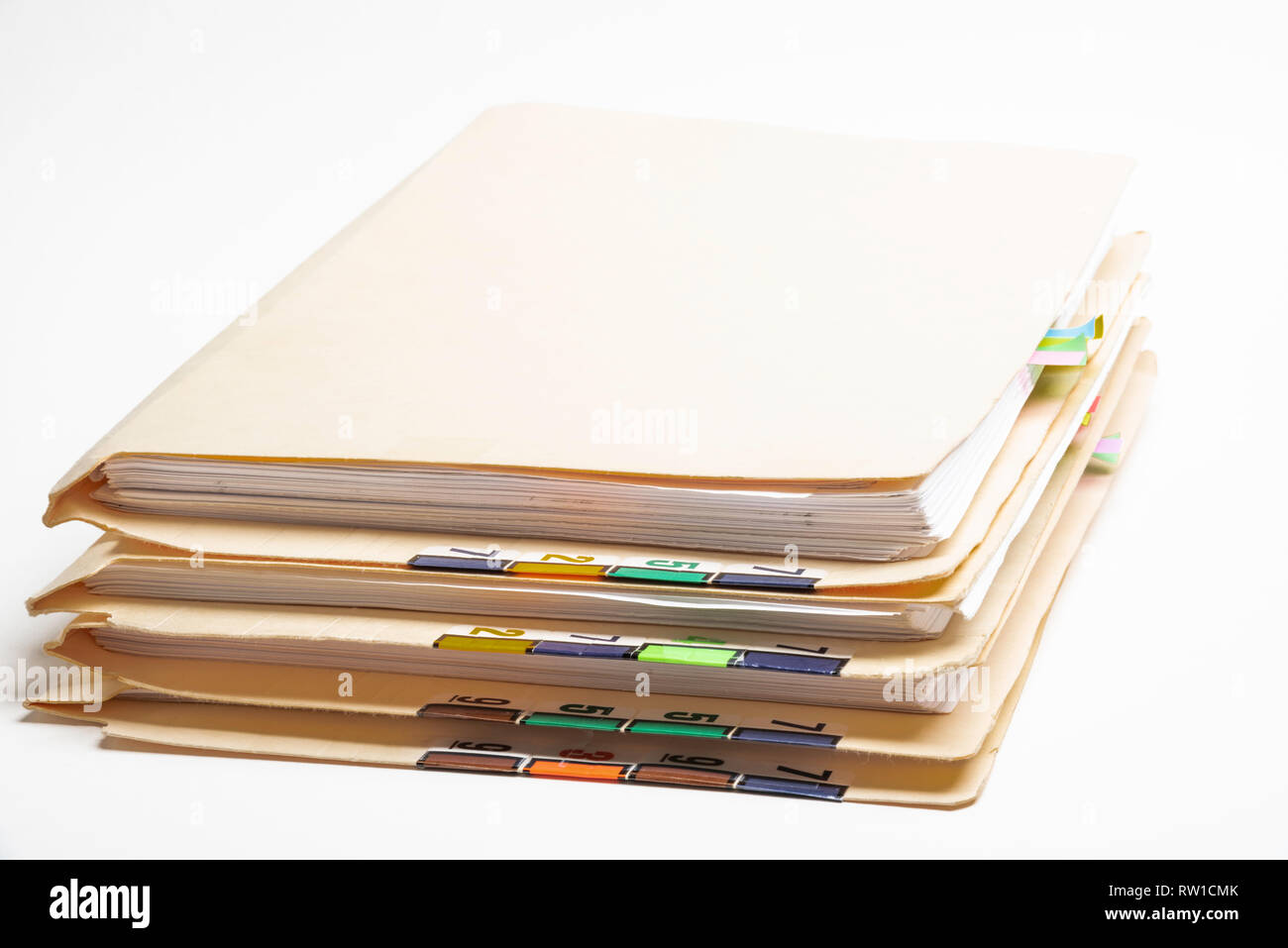 A stack of patient medical records in folders with color-coded and ...