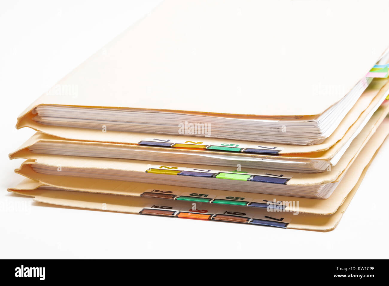 A stack of patient medical records in folders with color-coded and ...