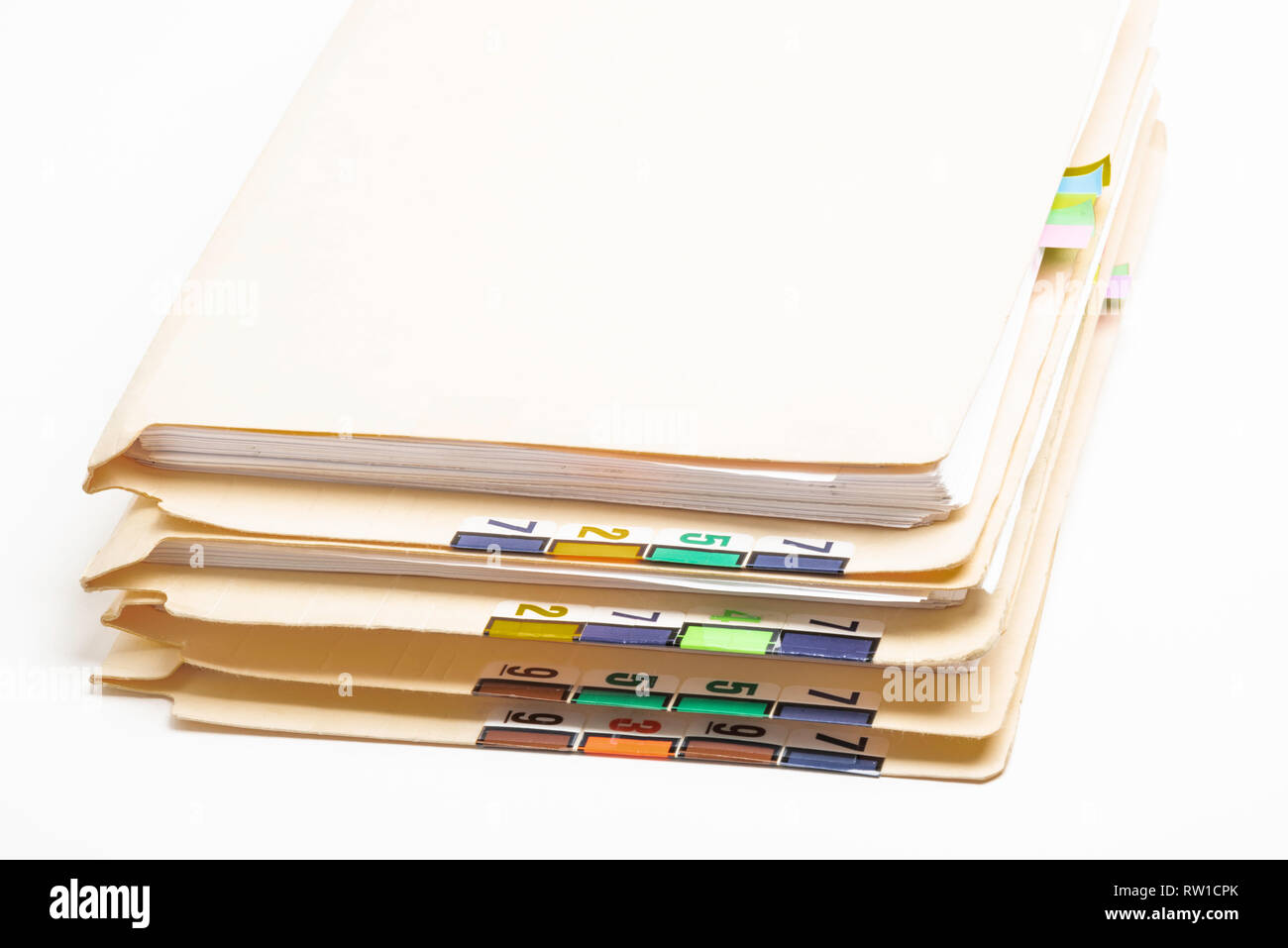 A stack of patient medical records in folders with color-coded and ...