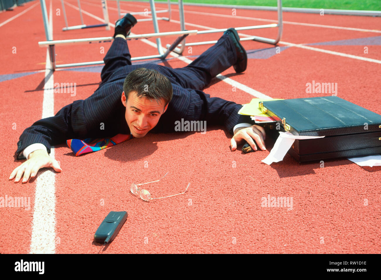 Young businessman fallen over hurdle on running track, USA Stock Photo ...