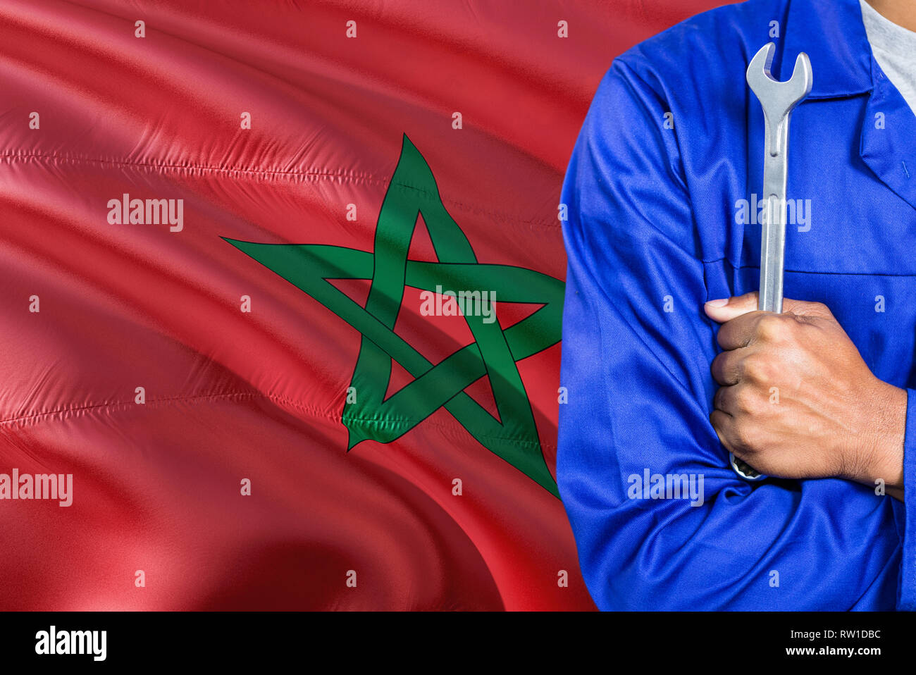 Moroccan Mechanic in blue uniform is holding wrench against waving ...