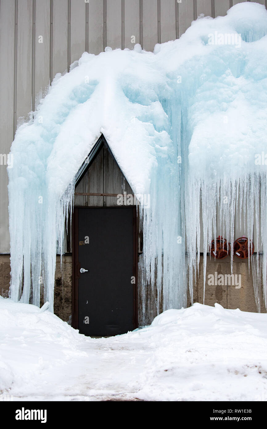 Big icicles over a door in Wisconsin vertical Stock Photo - Alamy