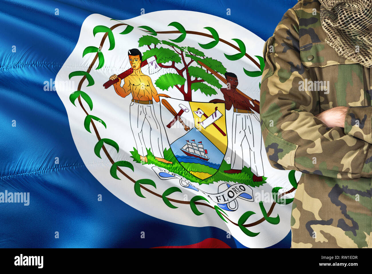 Crossed arms Belizean soldier with national waving flag on background ...