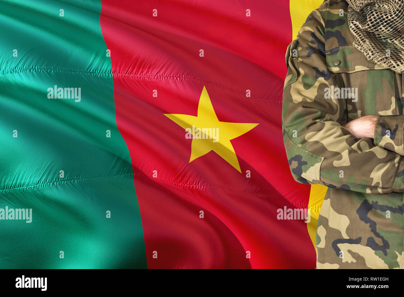 Crossed arms Cameroonian soldier with national waving flag on ...
