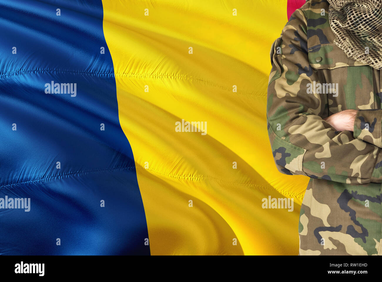 Crossed arms Chadian soldier with national waving flag on background ...