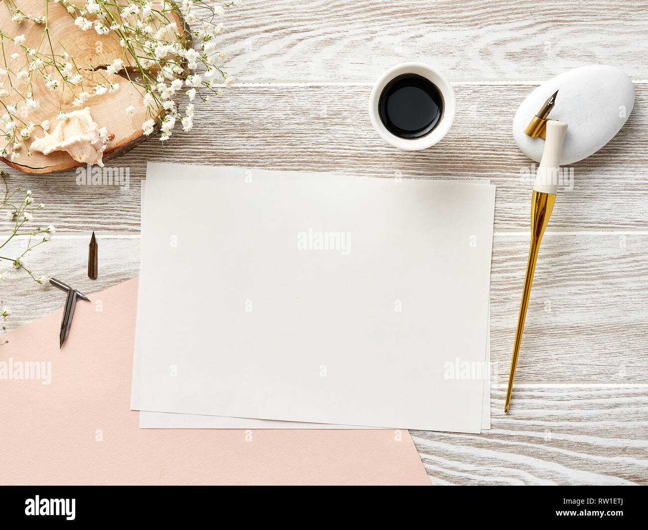 Mock up of blank paper for invitation or letter on white wooden ...