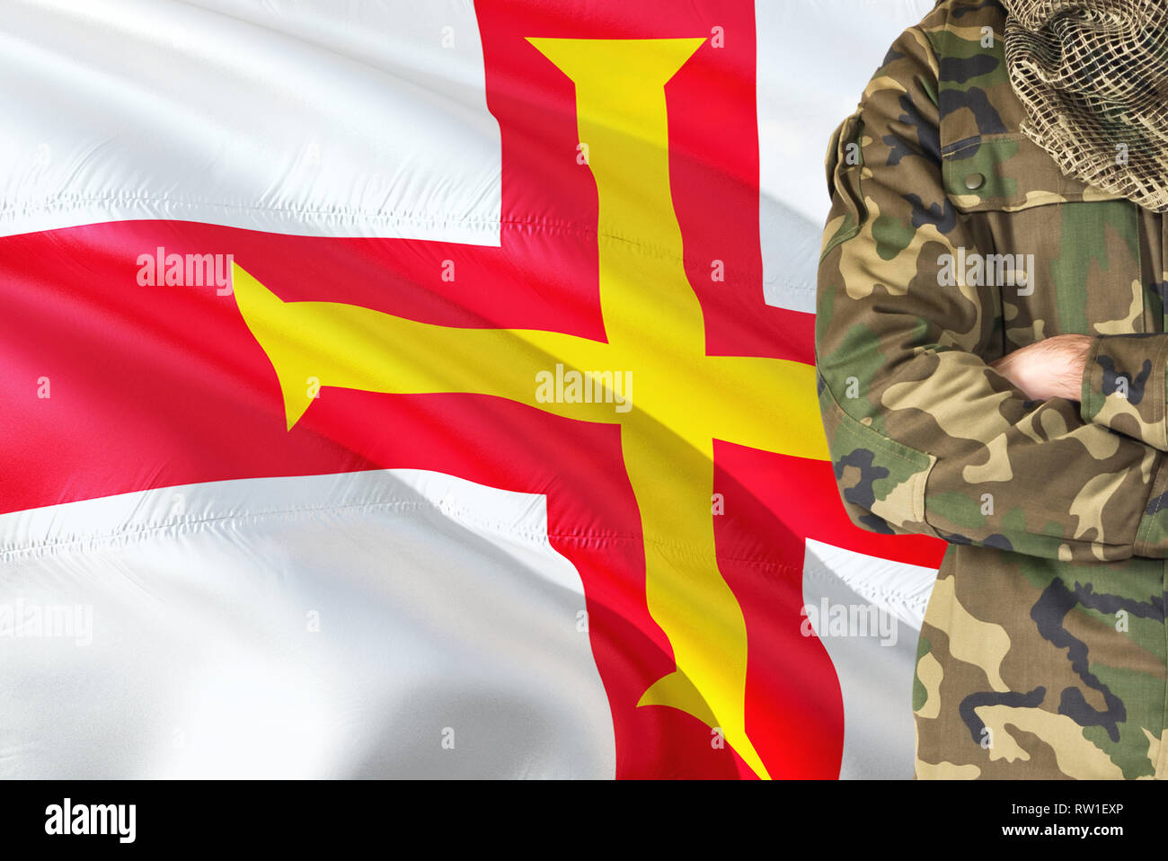 Crossed arms soldier with national waving flag on background - Guernsey ...