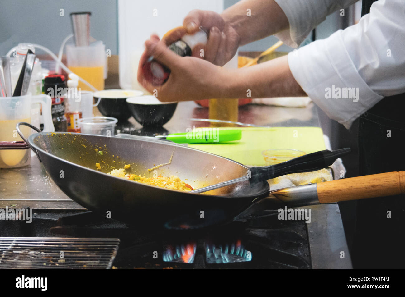 Chef cooking with flame in a frying pan on a kitchen stove, Chef in ...