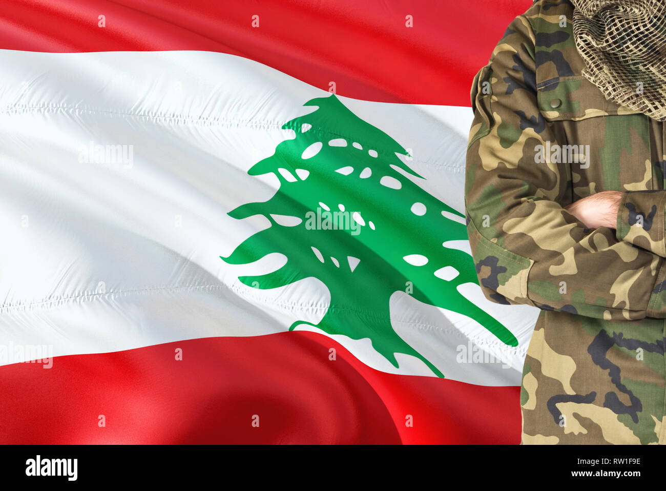 Crossed arms Lebanese soldier with national waving flag on background ...