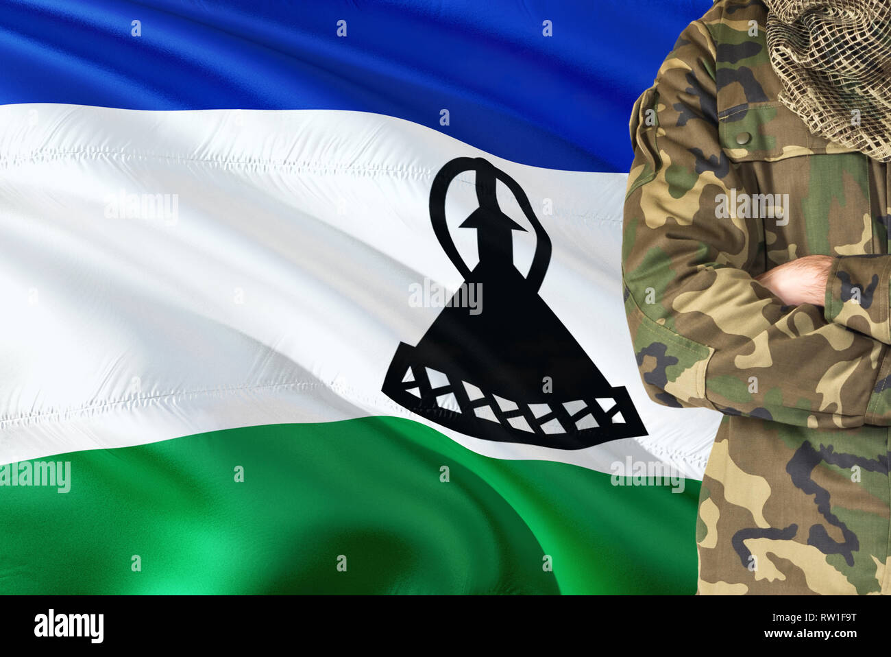 Crossed arms soldier with national waving flag on background - Lesotho ...
